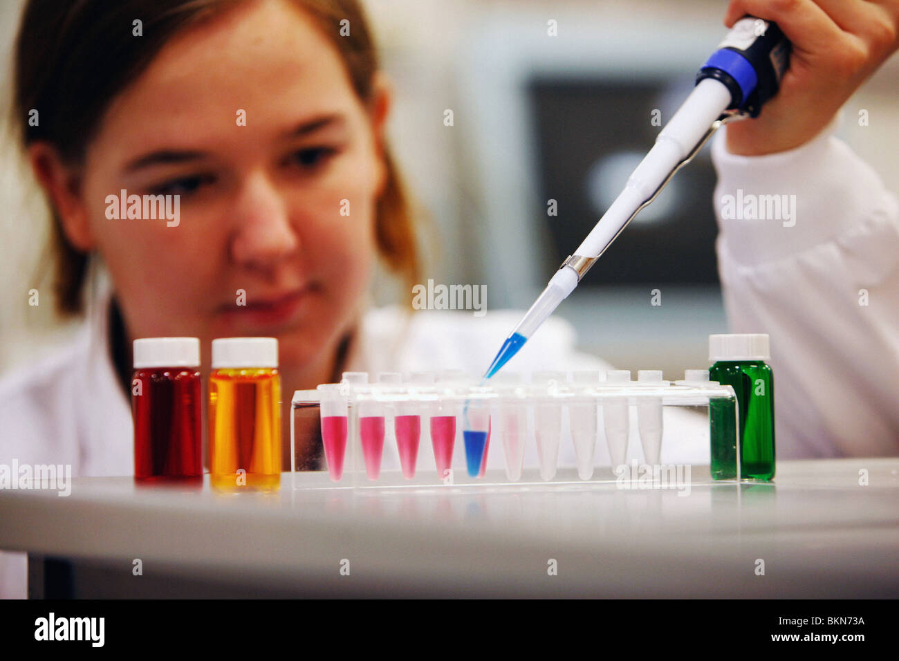 Female university student in a science lab performing an experiment ...