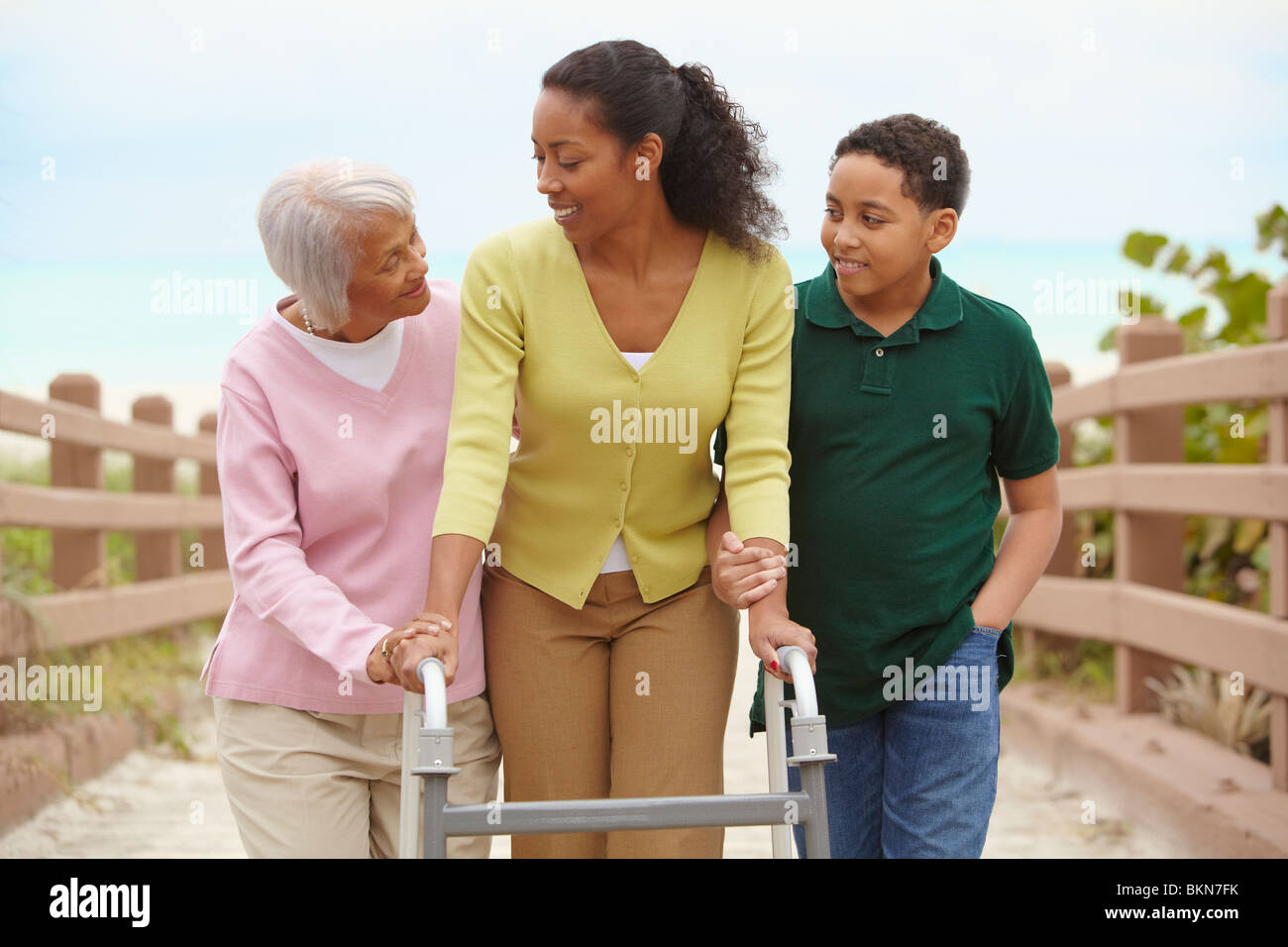 African American woman using walker with help of family Stock Photo - Alamy