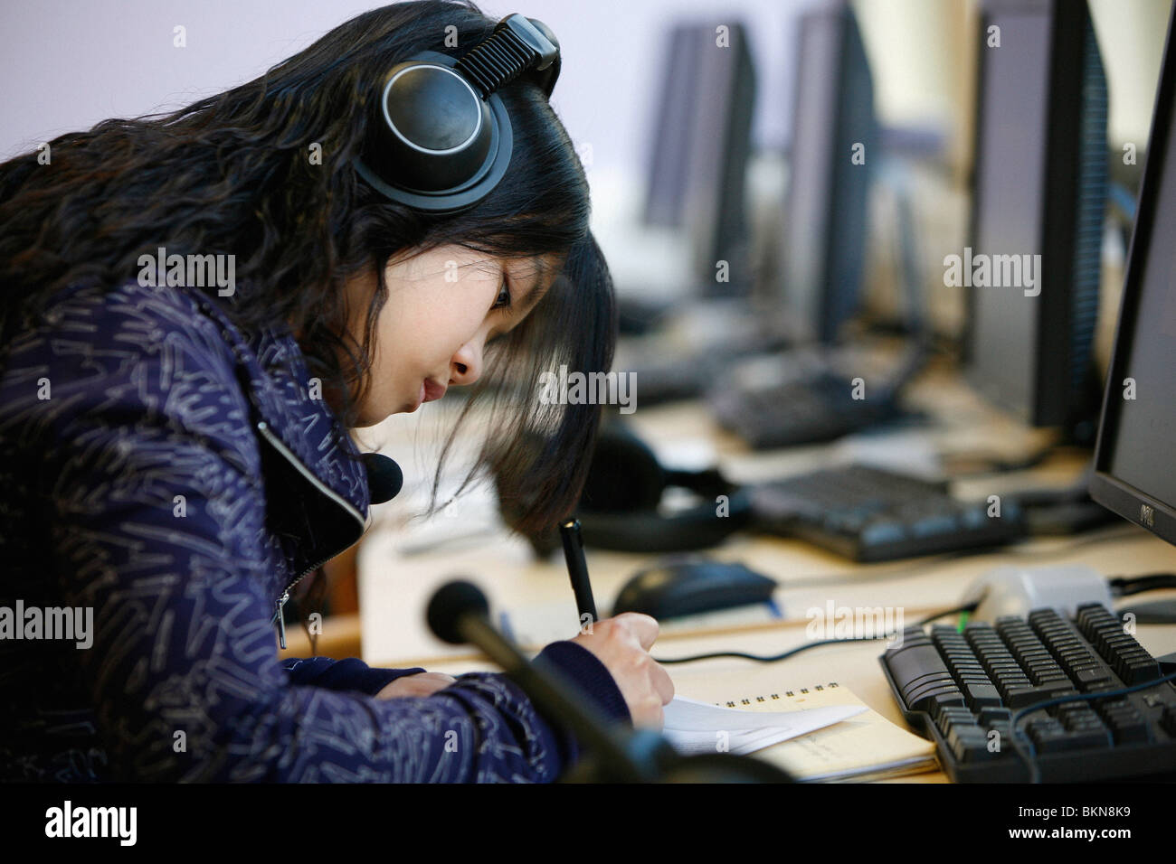 Student at university using headphones to study Stock Photo - Alamy