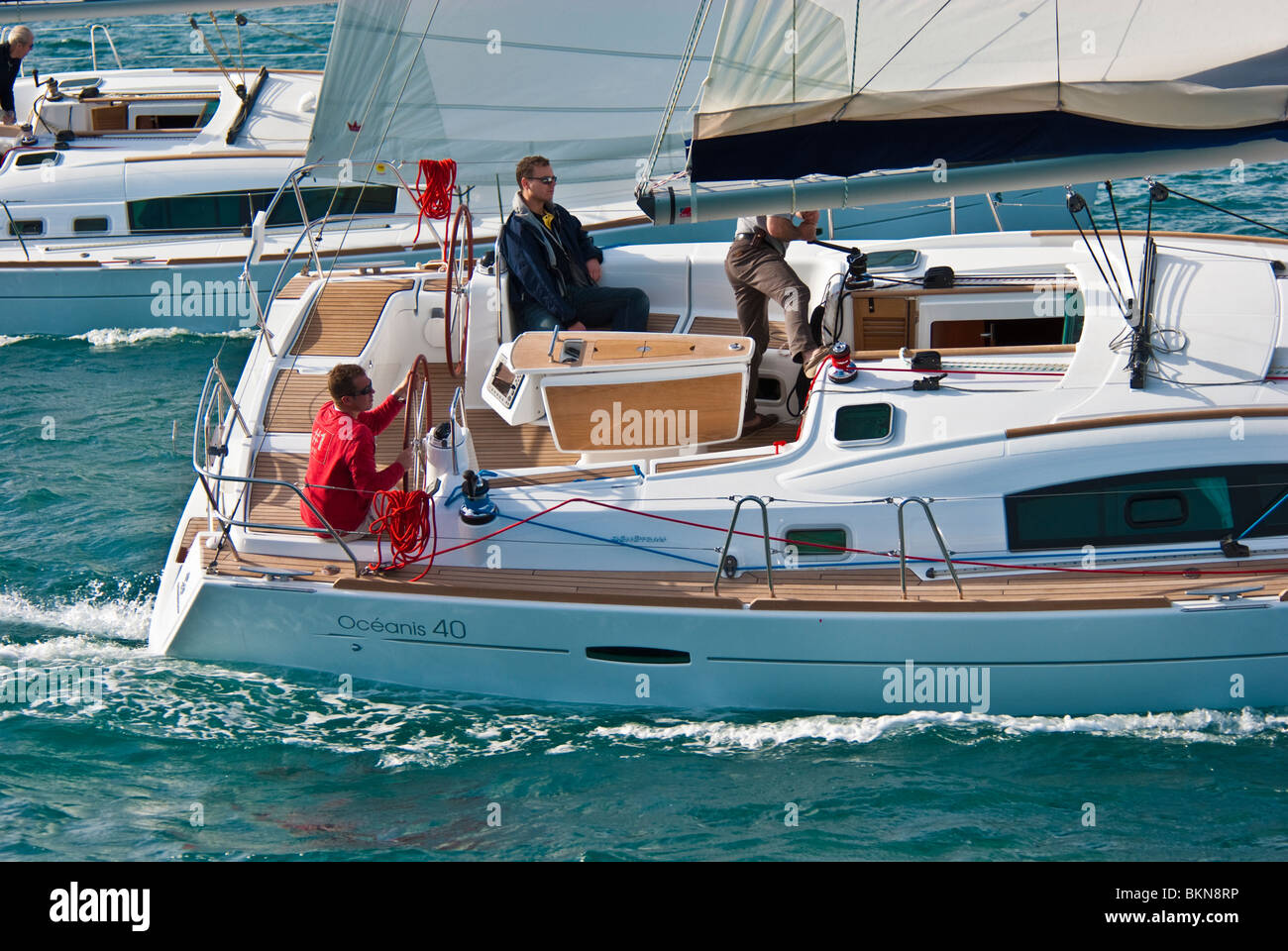 Helmsman or skipper with crew in cockpit of Beneteau Oceanis 40, stern ...