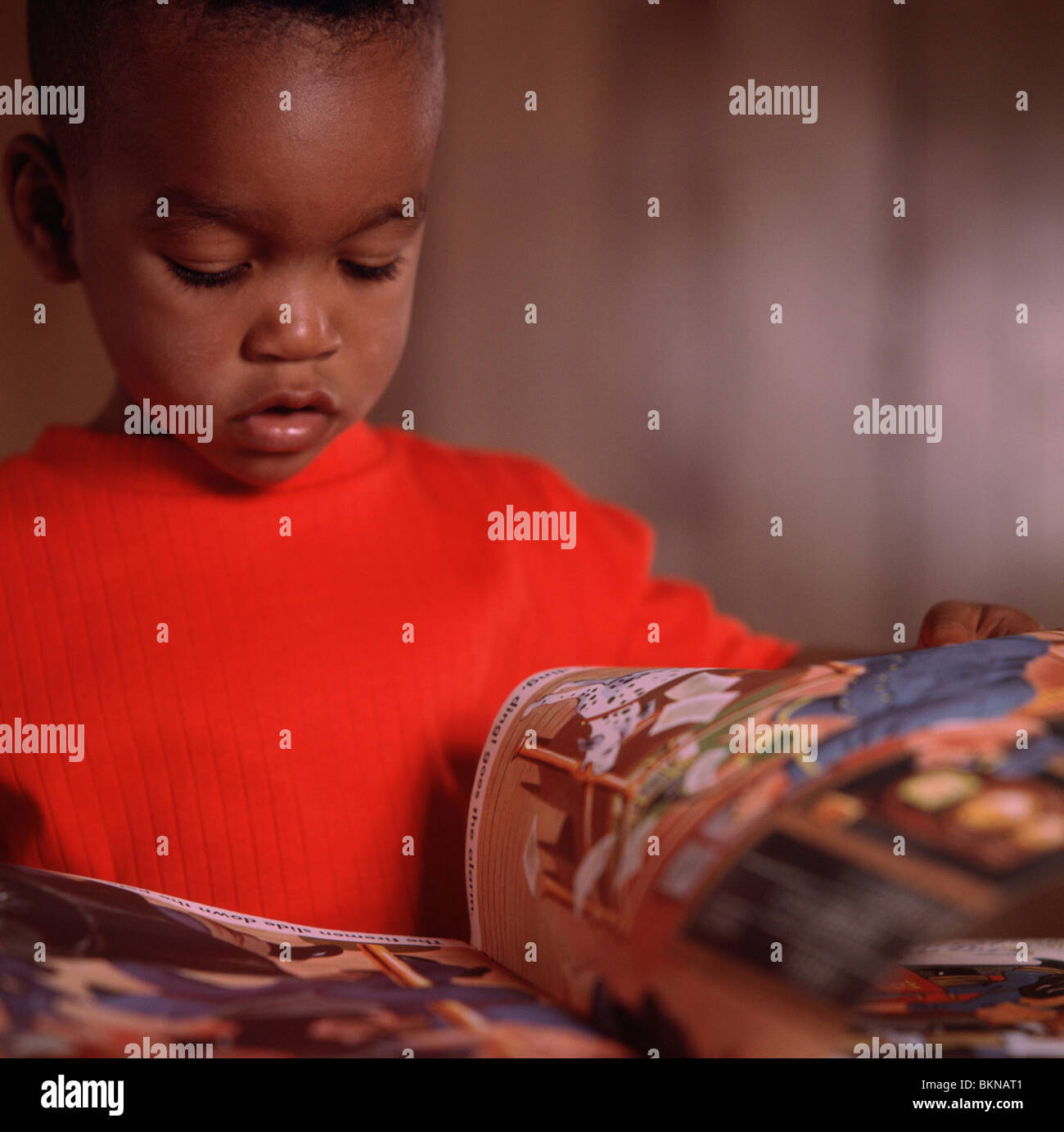 Young African American boy flipping through pages of a book Stock Photo ...