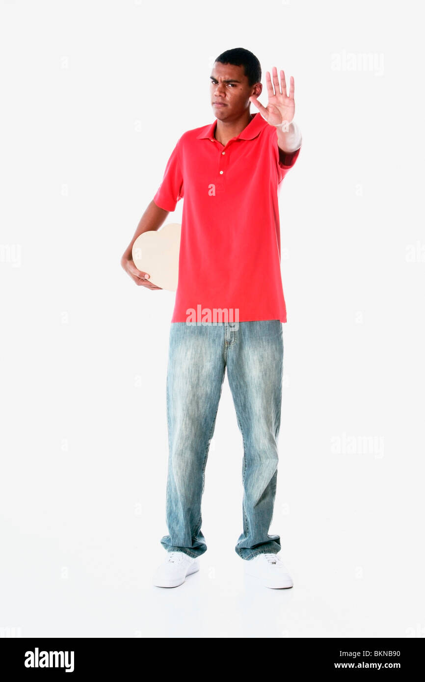 A Young Man Holding Out His Hand To Say Stop Holding A Heart Behind His ...