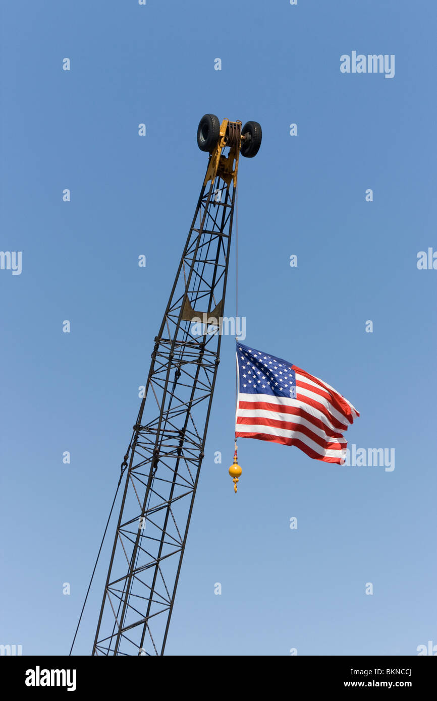 American flag hanging from the cable on the boom of a crane Stock Photo ...