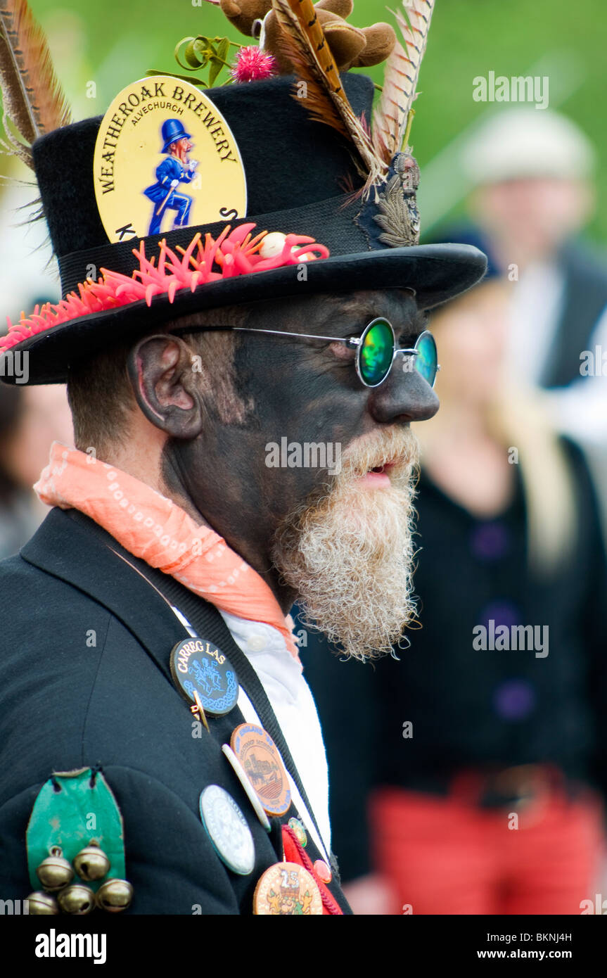 A morris dancer or morris man in costume with a blacked face and dark ...
