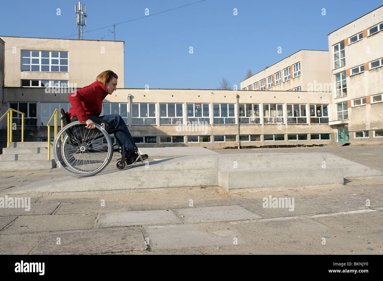 Handicapped woman practicing wheelchair riding over obstacle course for ...