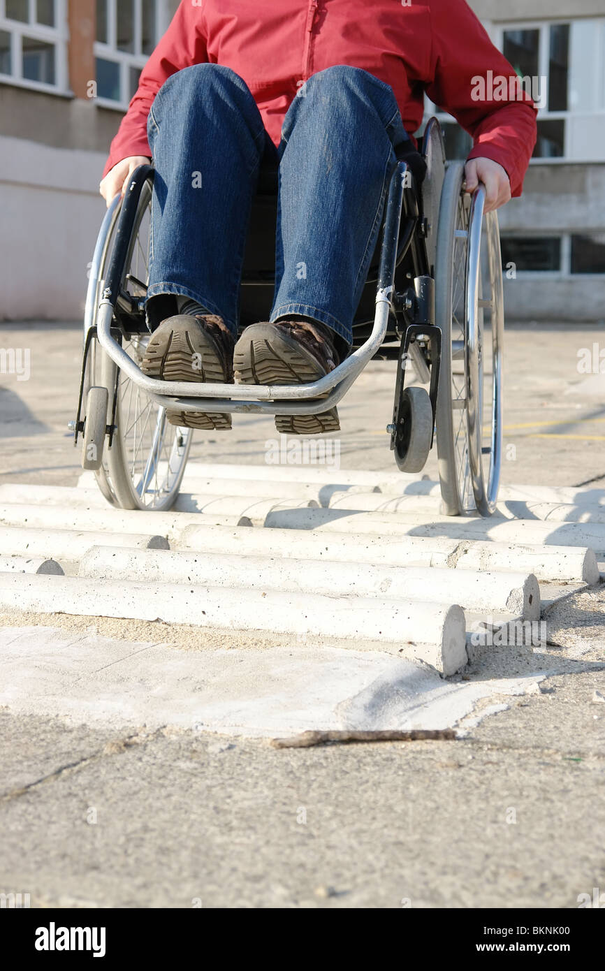 Closeup of handicapped woman practicing wheelchair riding over obstacle ...