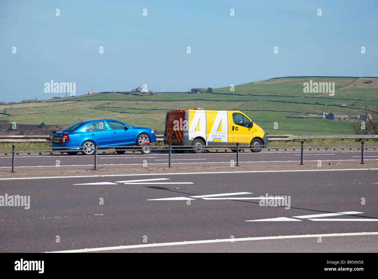 AA van on the M62 (towing a blue saloon car Stock Photo - Alamy