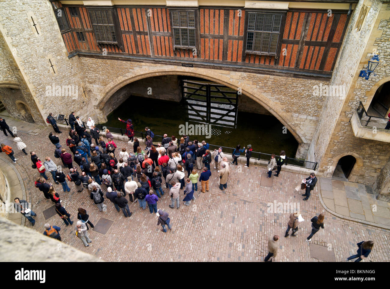 A Yeoman warder or Beefeater guiding tourists near Traitor's gate in ...