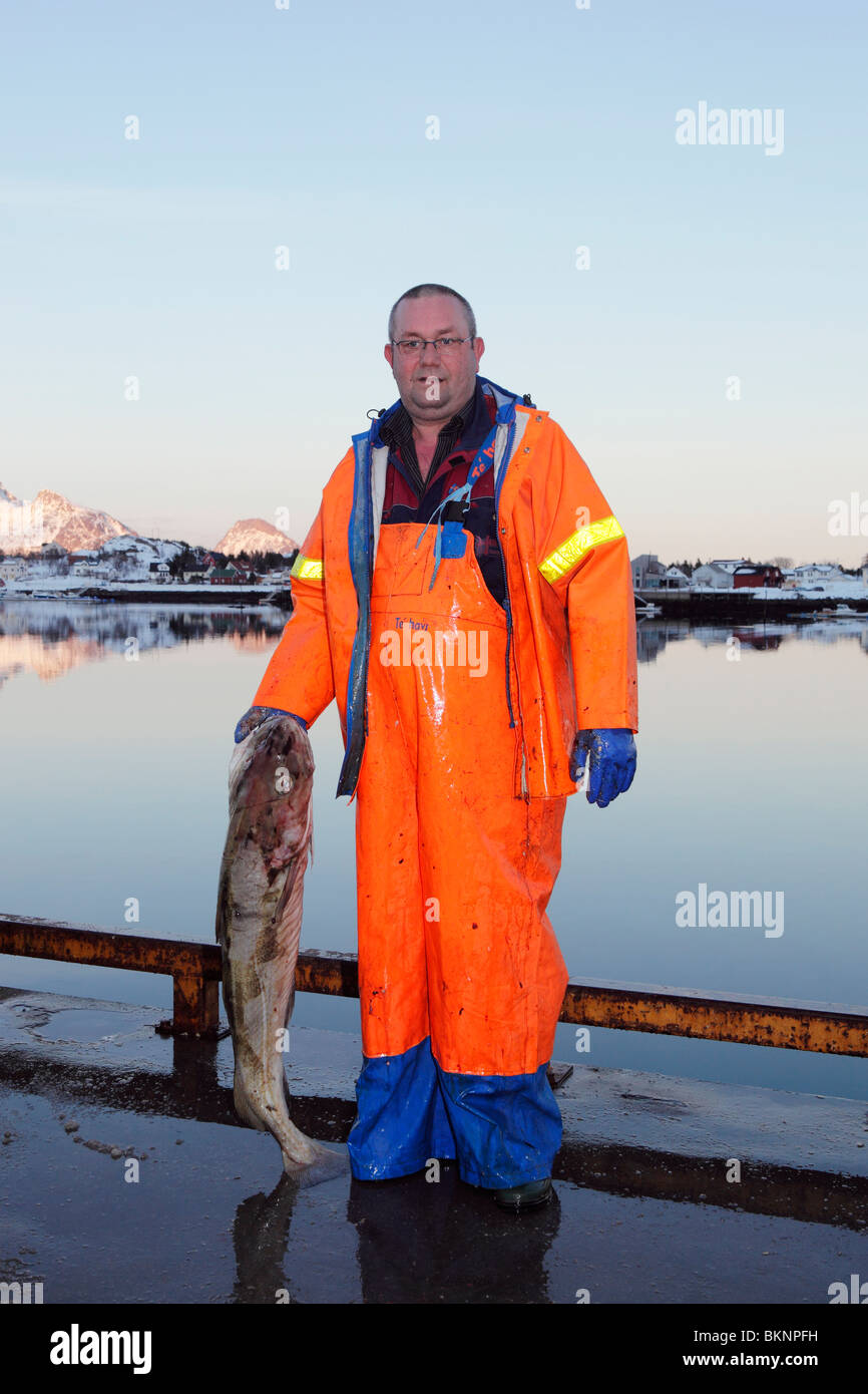 A fisherman holds one of his line-caught cod fish in Ballstad fishing ...
