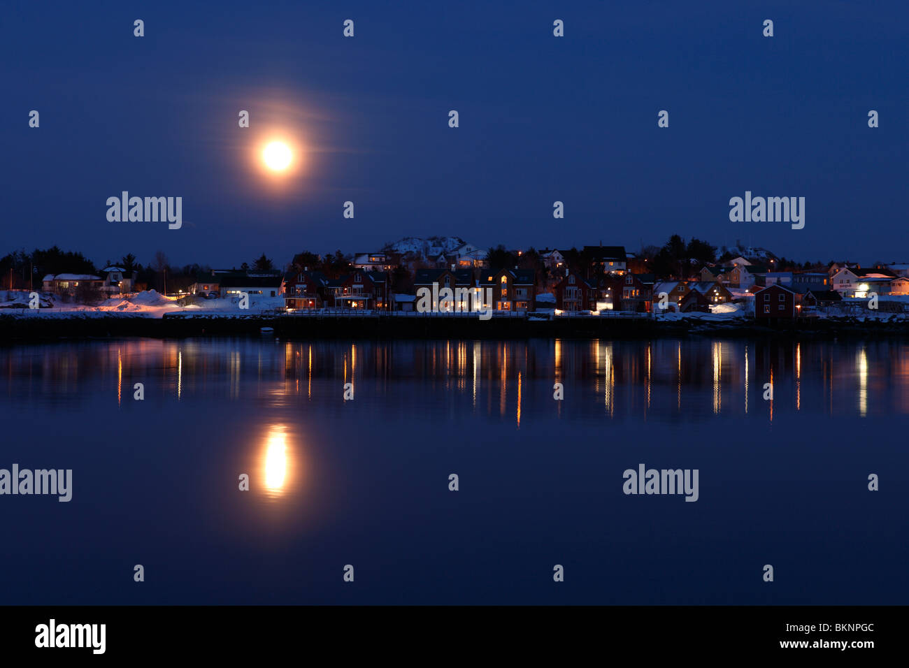 Houses reflected across the harbour of Ballstad fishing village on ...