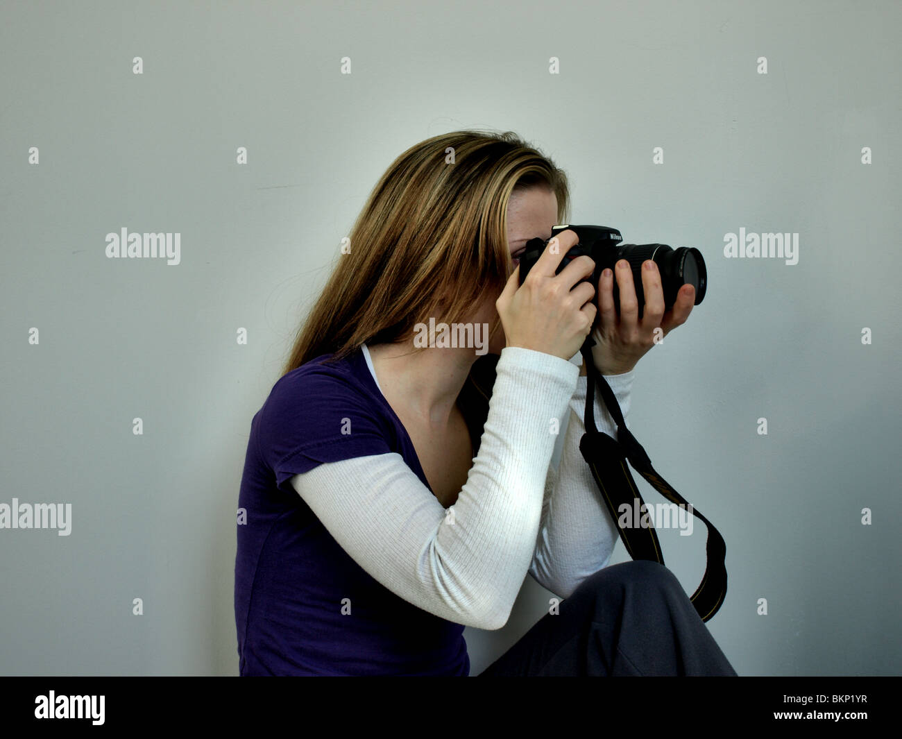 female woman photographer taking photographs pictures using a black SLR ...