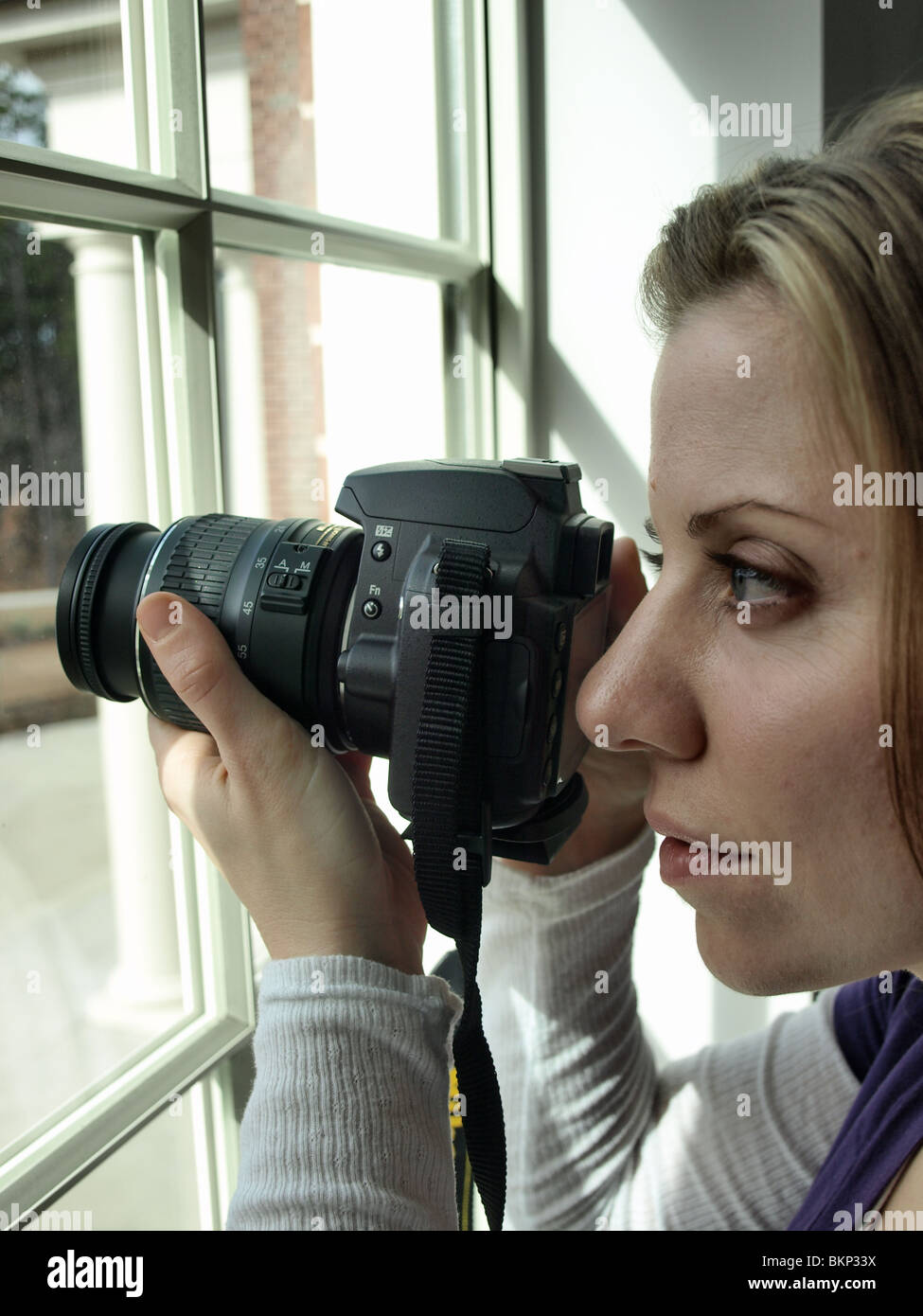 female woman photographer taking photographs pictures using a black SLR ...