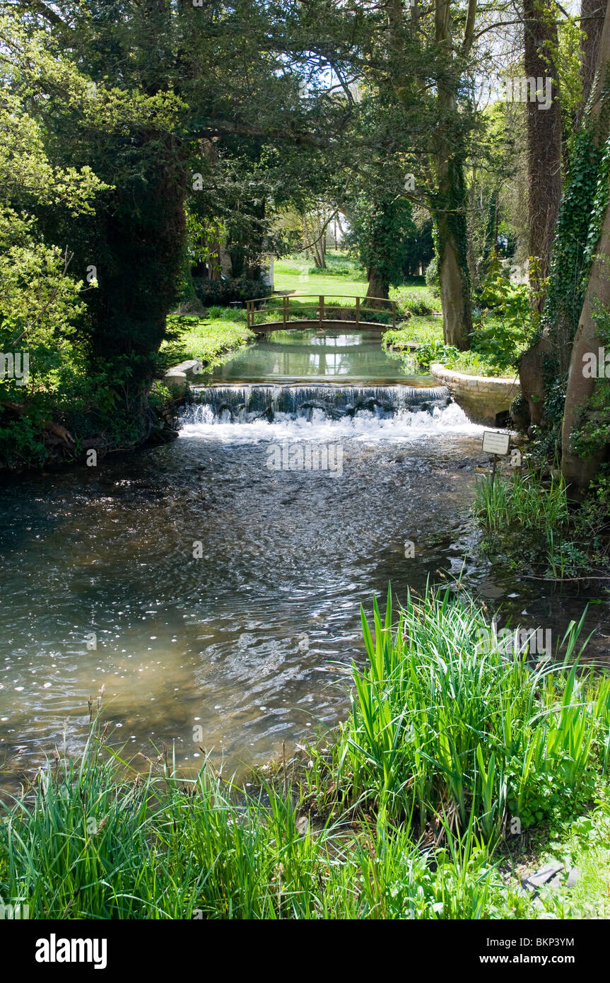 The river Glyme at Glympton, Oxfordshire, with a footbridge and small ...