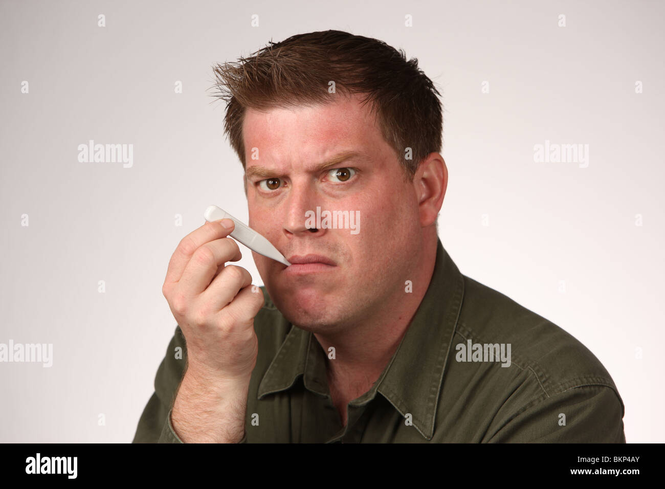 Sick Man With Fever Taking His Temperature With Digital Thermometer In