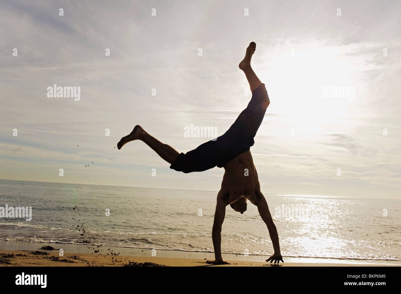 Young Man Doing A Cartwheel On The Beach Stock Photo - Alamy