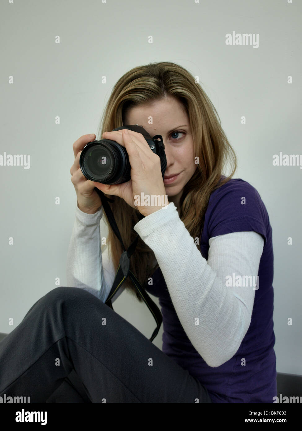 female woman photographer taking photographs pictures using a black SLR ...