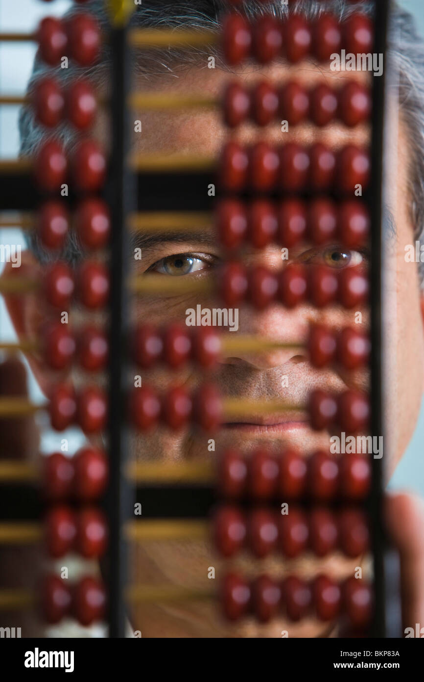 Man looking through abacus, portrait, close up Stock Photo - Alamy