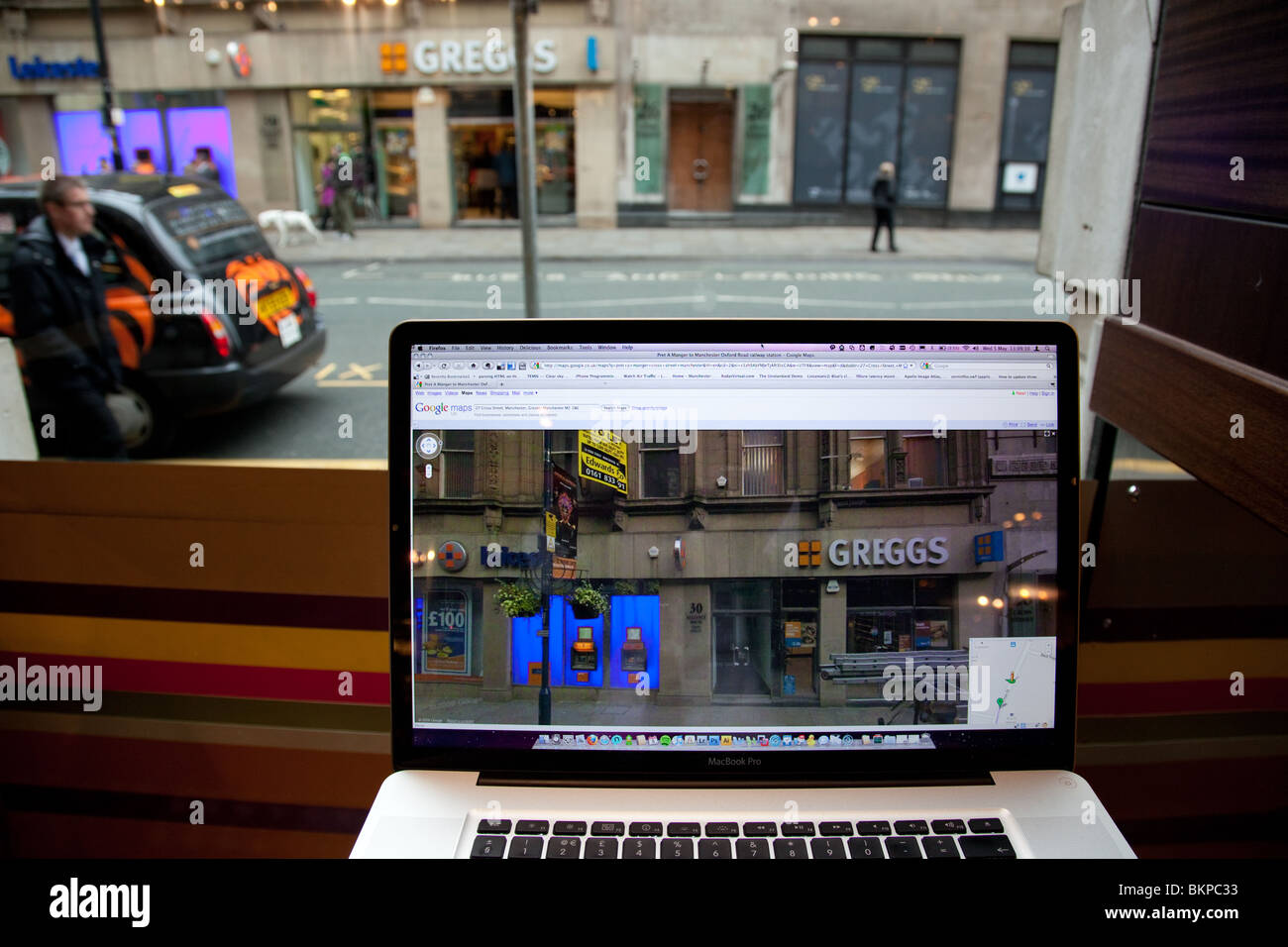 A view of a Manchester street with a laptop computer showing the same ...