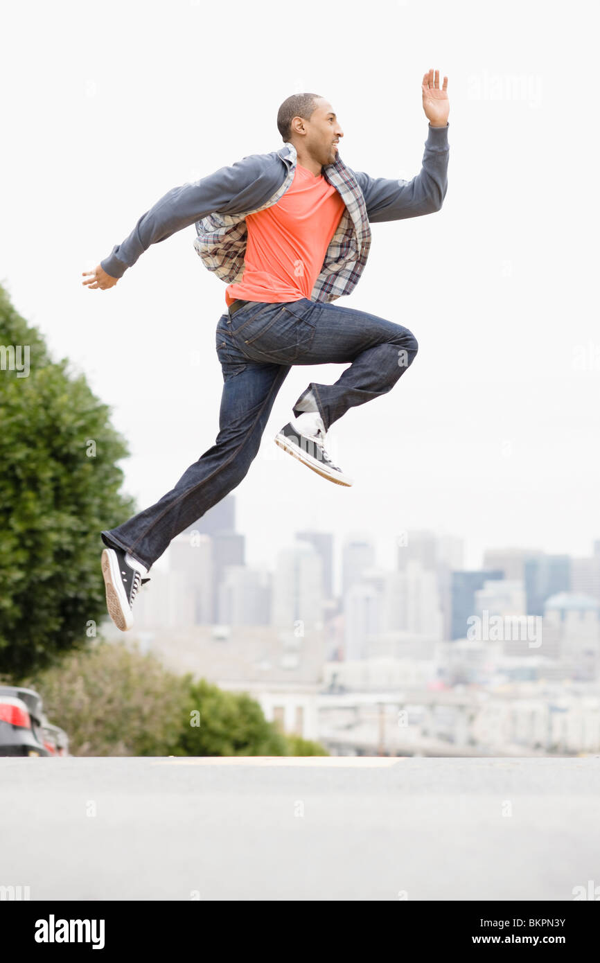 African American man running on urban street Stock Photo - Alamy