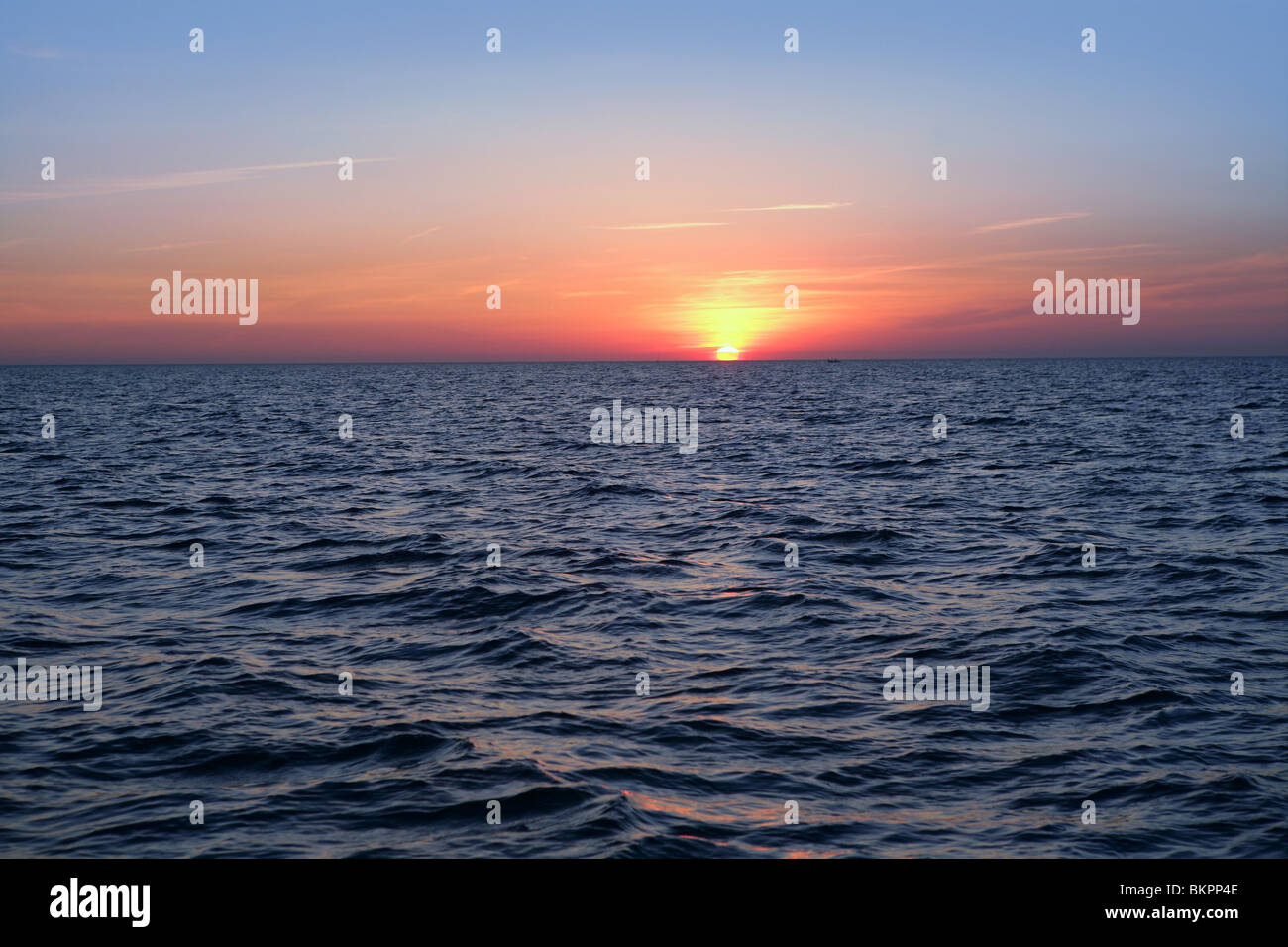 Beautiful sunset sunrise over blue sea ocean in red sky Stock Photo - Alamy
