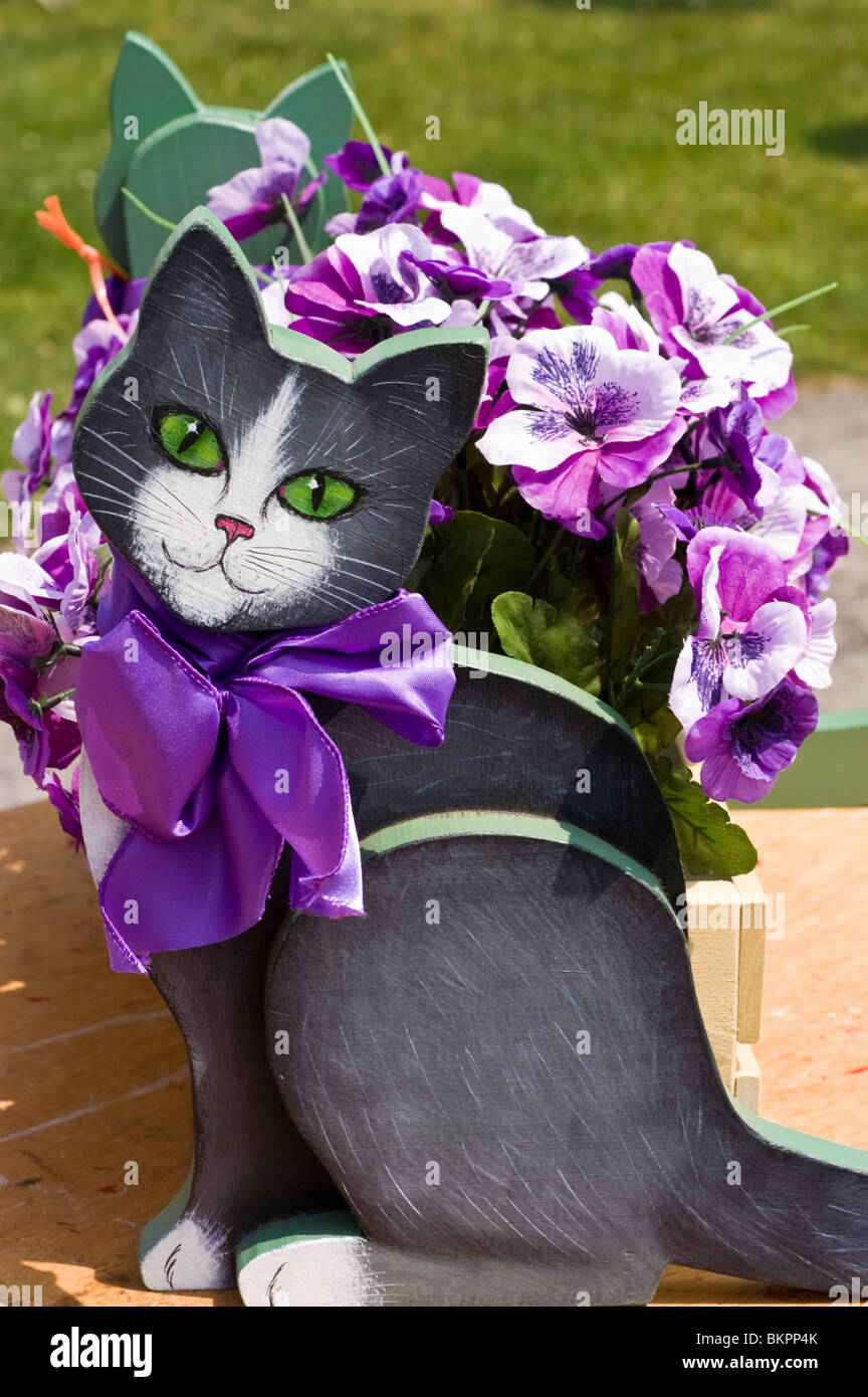 Green eyed wooden cat with flowers Stock Photo - Alamy
