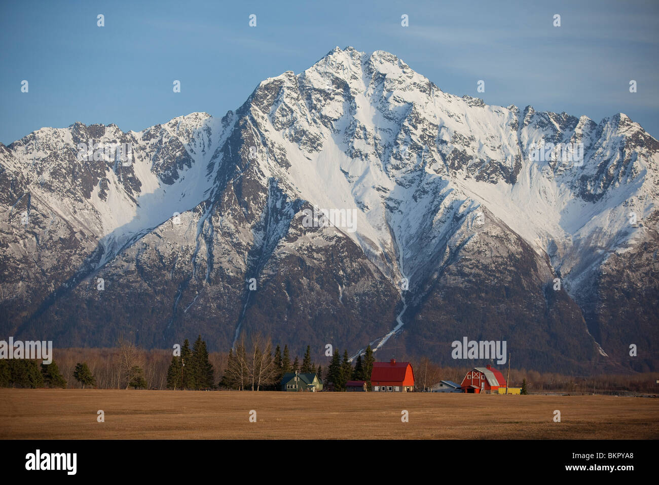 Red barns and homestead in Matanuska Valley with Chugach Mountains in ...