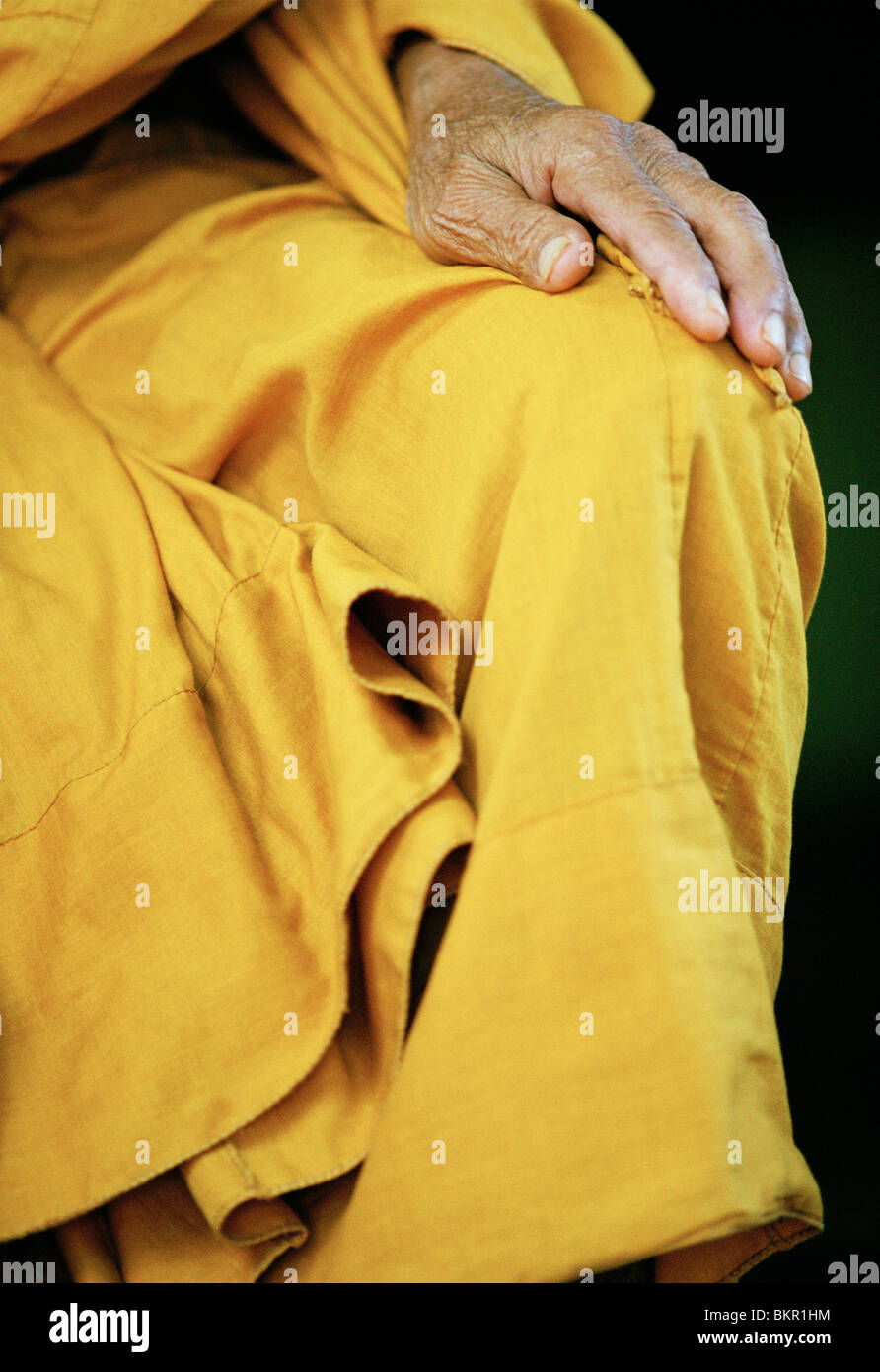 Old monk resting his hand on his knee, Sukhothai Thailand Stock Photo ...
