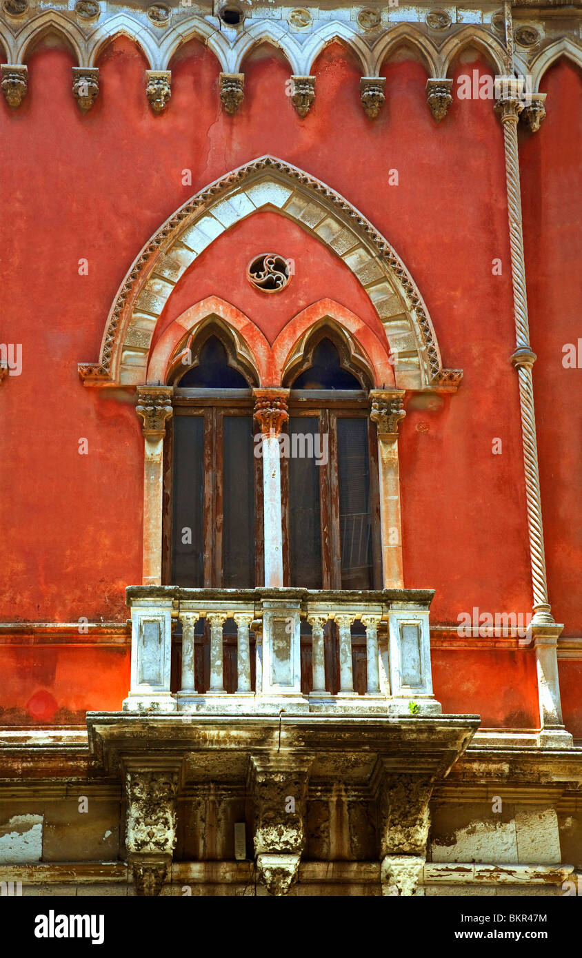 Italy, Sicily, Siracuse; A bright red-painted facade of a palace in ...