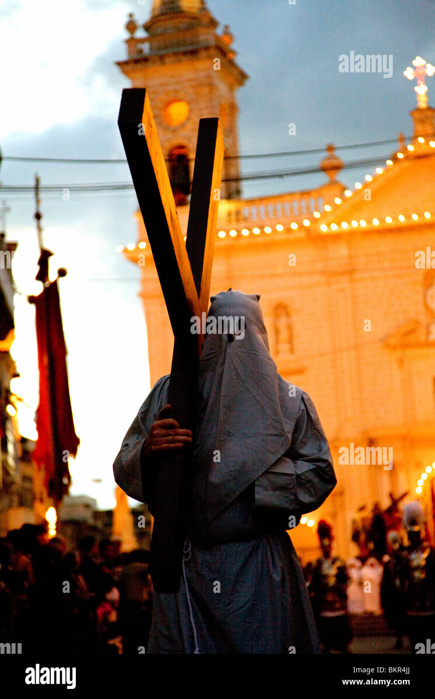 Europe, Malta, Qormi; A caped cross bearer walking barefoot during the ...