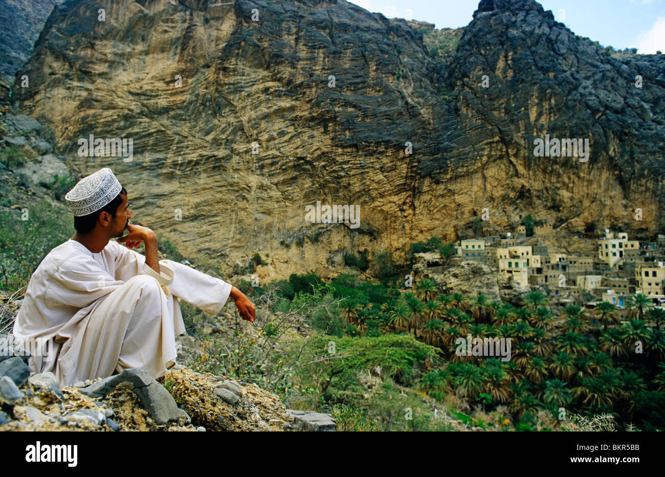 Oman, Dakhiliyah, Jebel Hajar, Wajmah. A man contemplates the view near ...