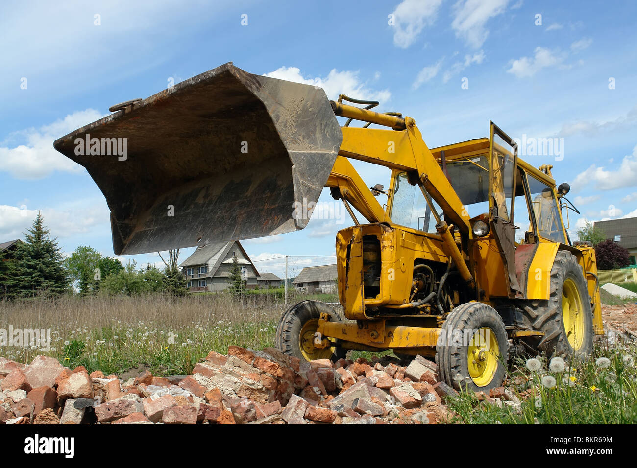 Yellow backhoe loader working with brick debris Stock Photo - Alamy