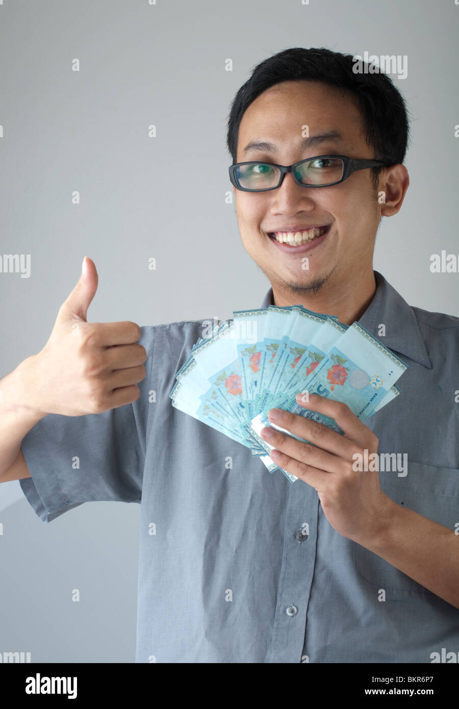 happy asian man with a lot of malaysian money Stock Photo - Alamy