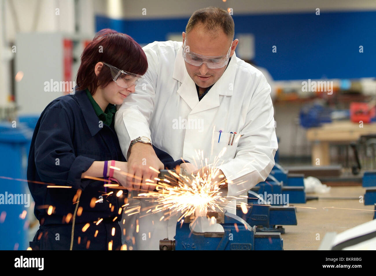 Young female engineering student being instructed in correct use of an ...