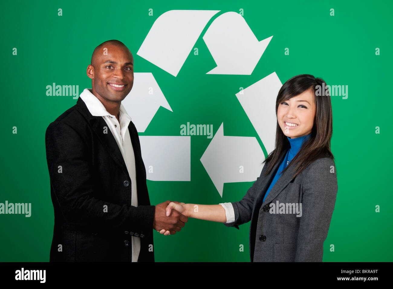 Two Business People Shaking Hands In Front Of A Recycle Symbol Stock ...