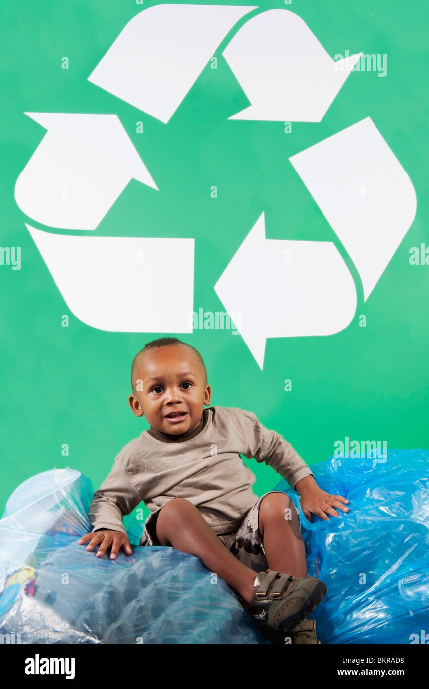 A Young Boy With Bags Of Recycle Items Under A Recycle Sign Stock Photo ...