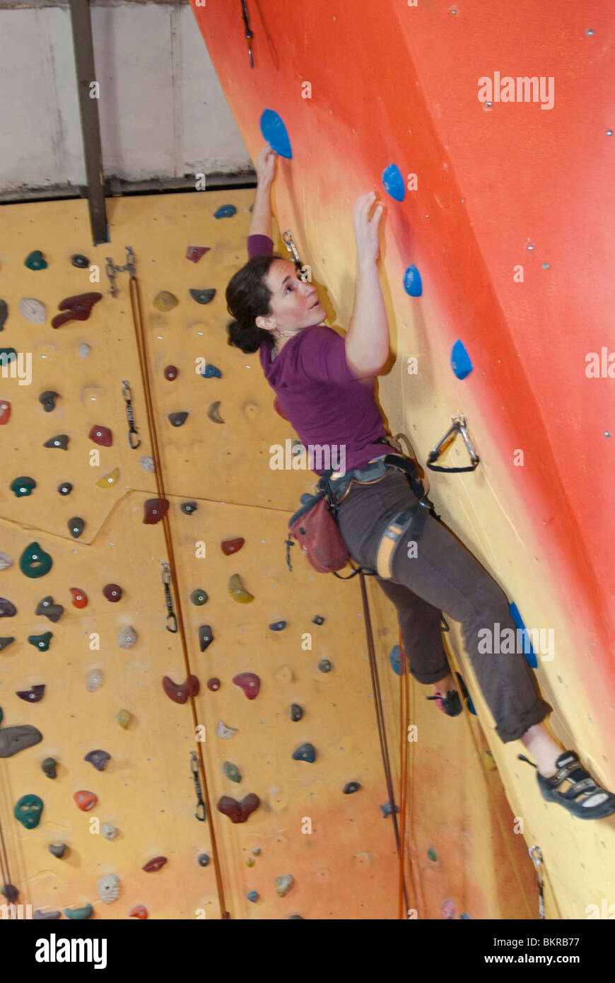 Female climbing at an indoor climbing wall Stock Photo - Alamy