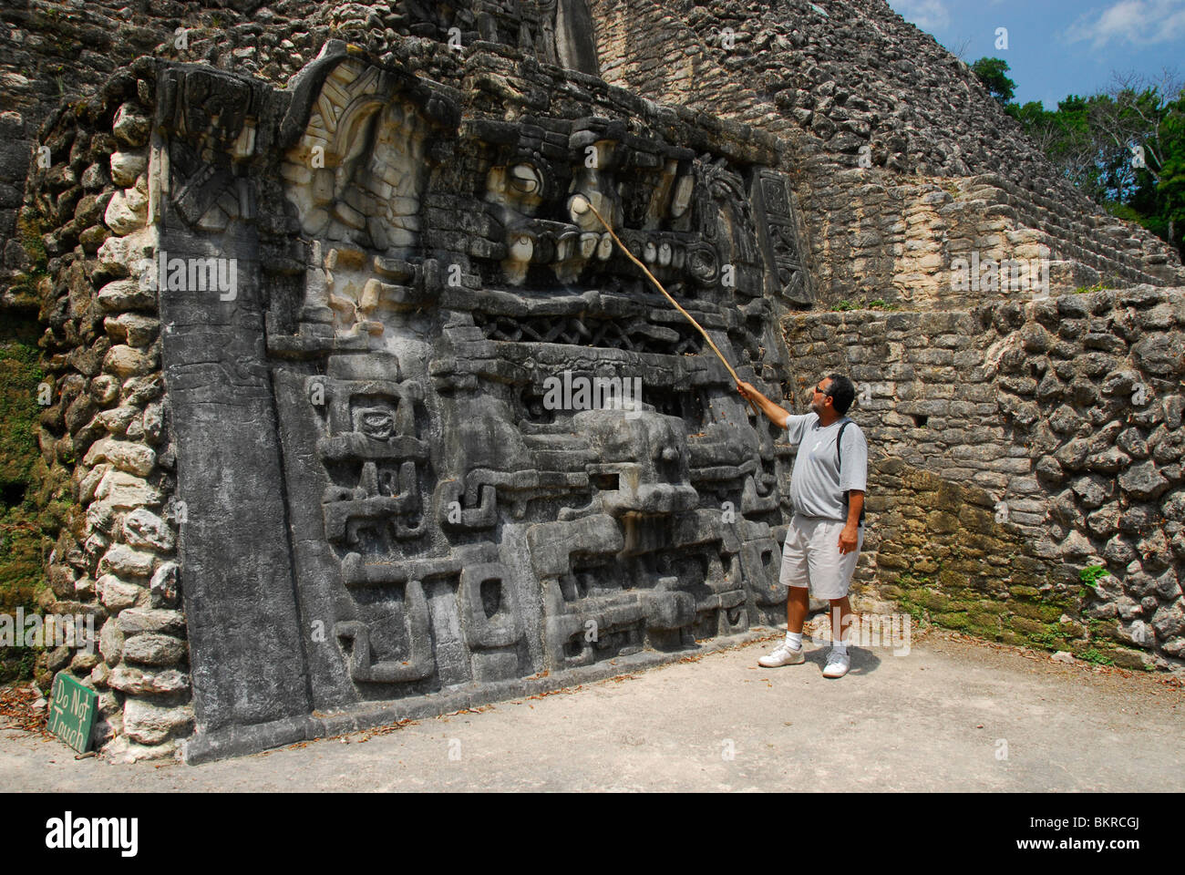 Guide explaining relief in Caracol ruins, Mayan Mountains, Cayo ...