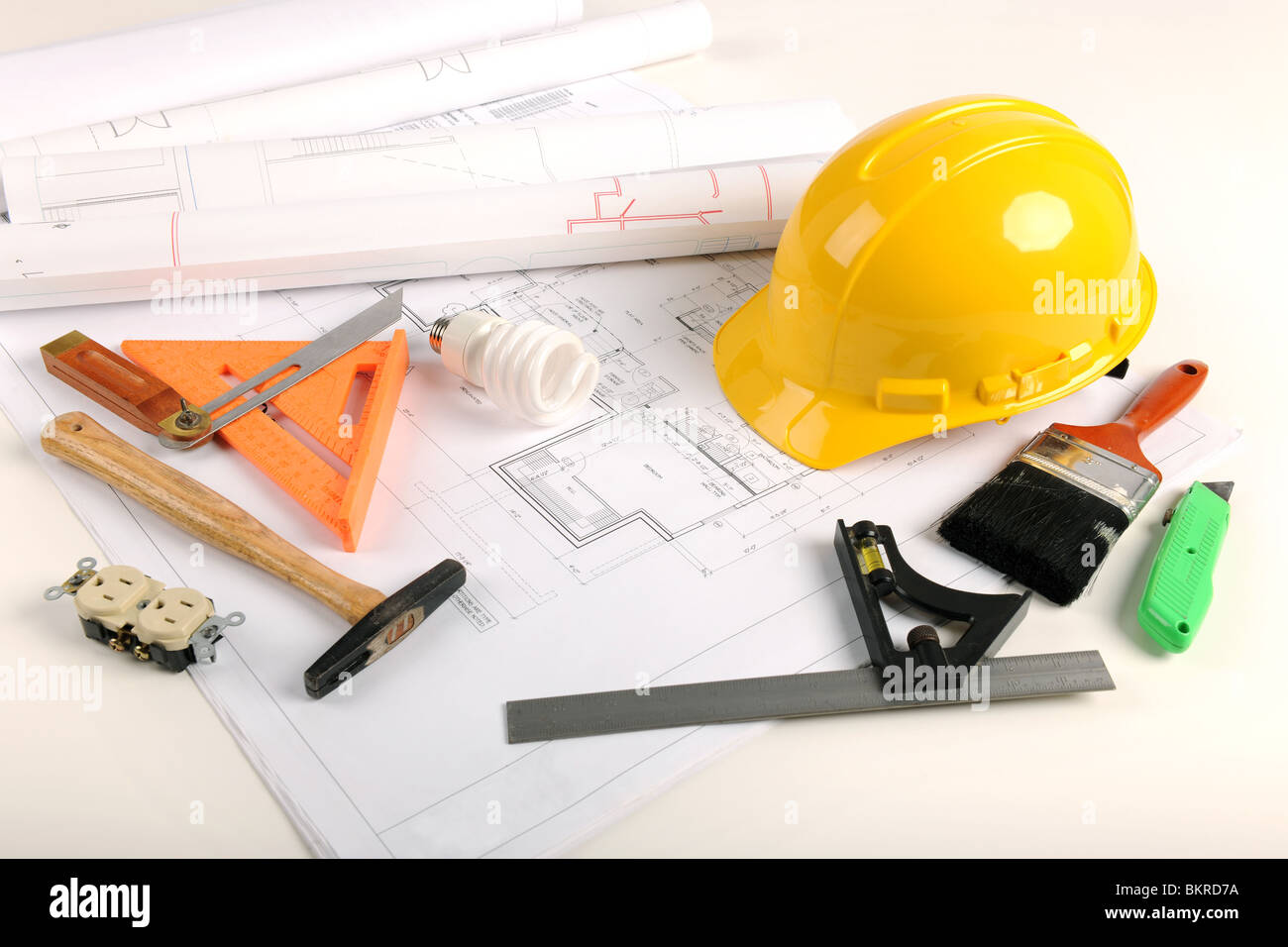 Architectural plans, hardhat and tool over draft table Stock Photo - Alamy