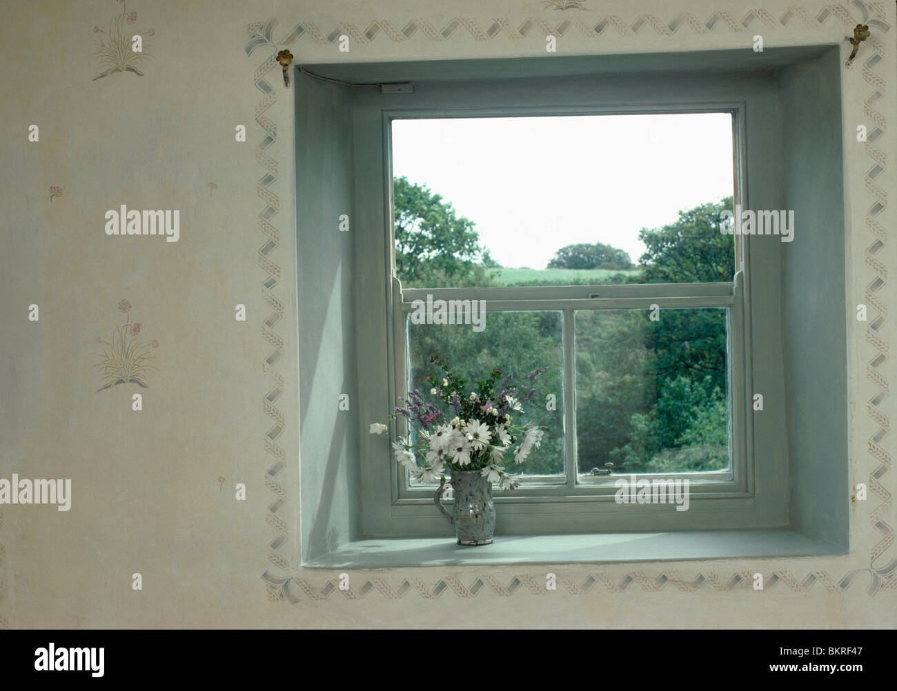 Close-up of window with stenciled border and blue gray-green frame ...