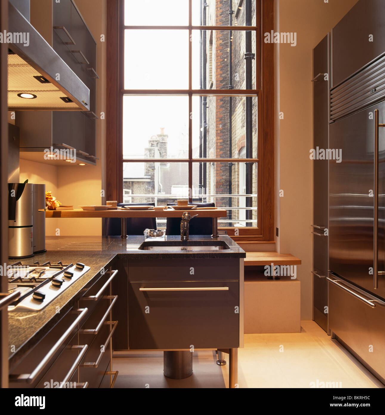 Modern townhouse kitchen with steel handles on granite-topped units ...