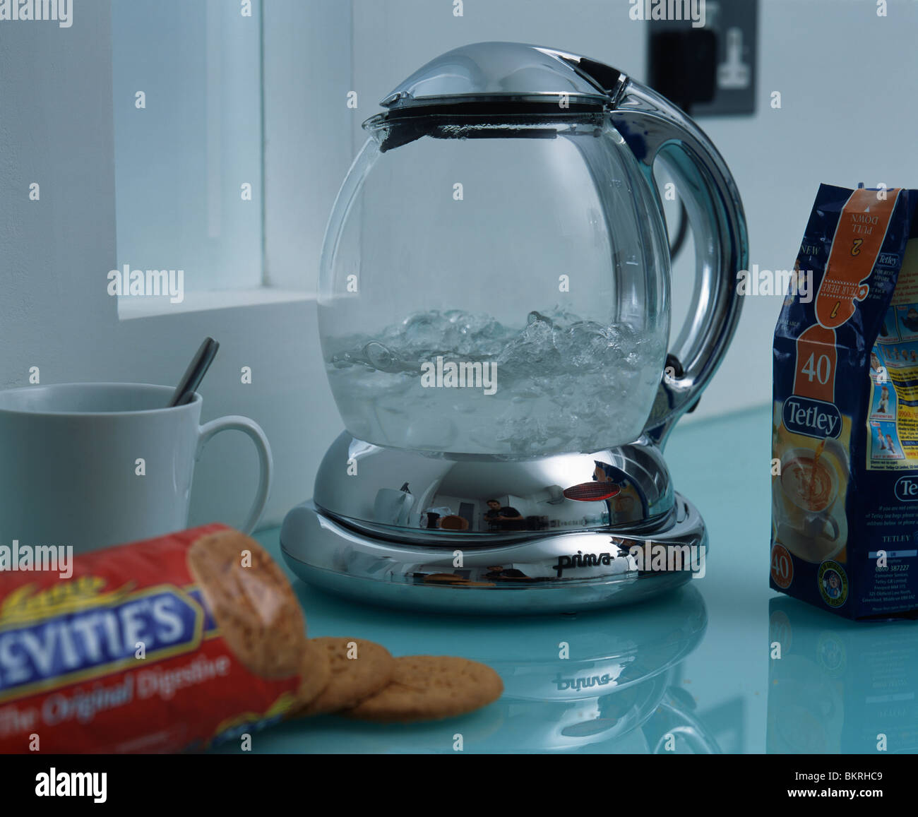 Close-up of clear perspex and chrome kettle on worktop with white cup ...