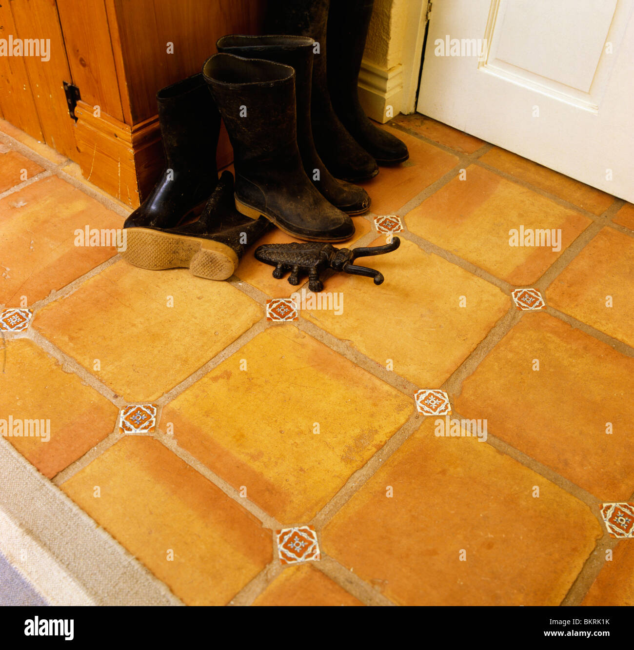 Close-up of boots on terracotta floor tiles Stock Photo - Alamy
