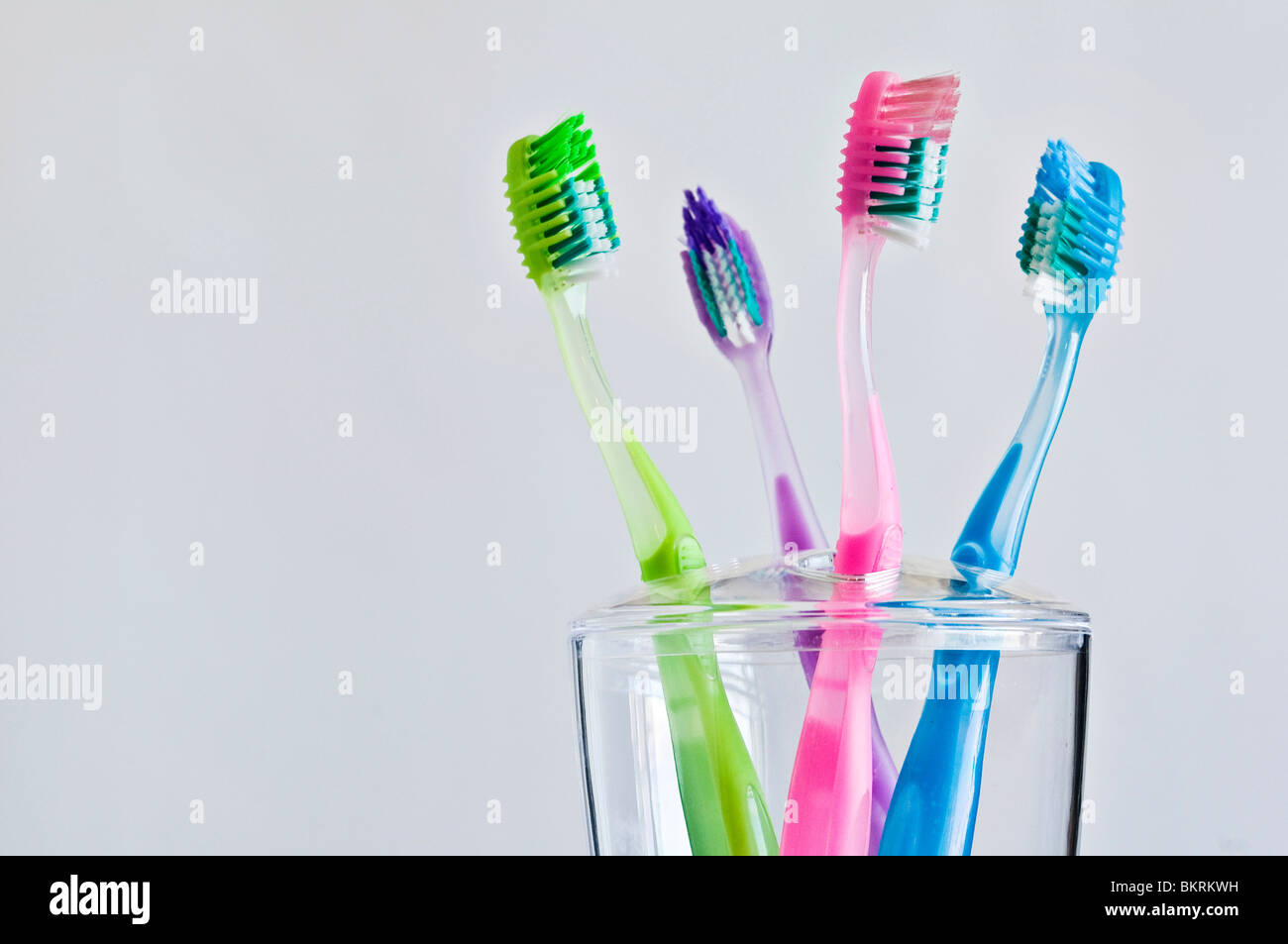 Four different colored toothbrushes in family toothbrush holder Stock ...