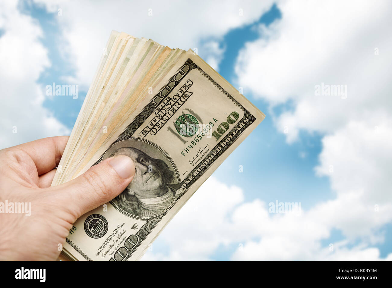 selective focus on nearest part, hand with money on blue sky background ...