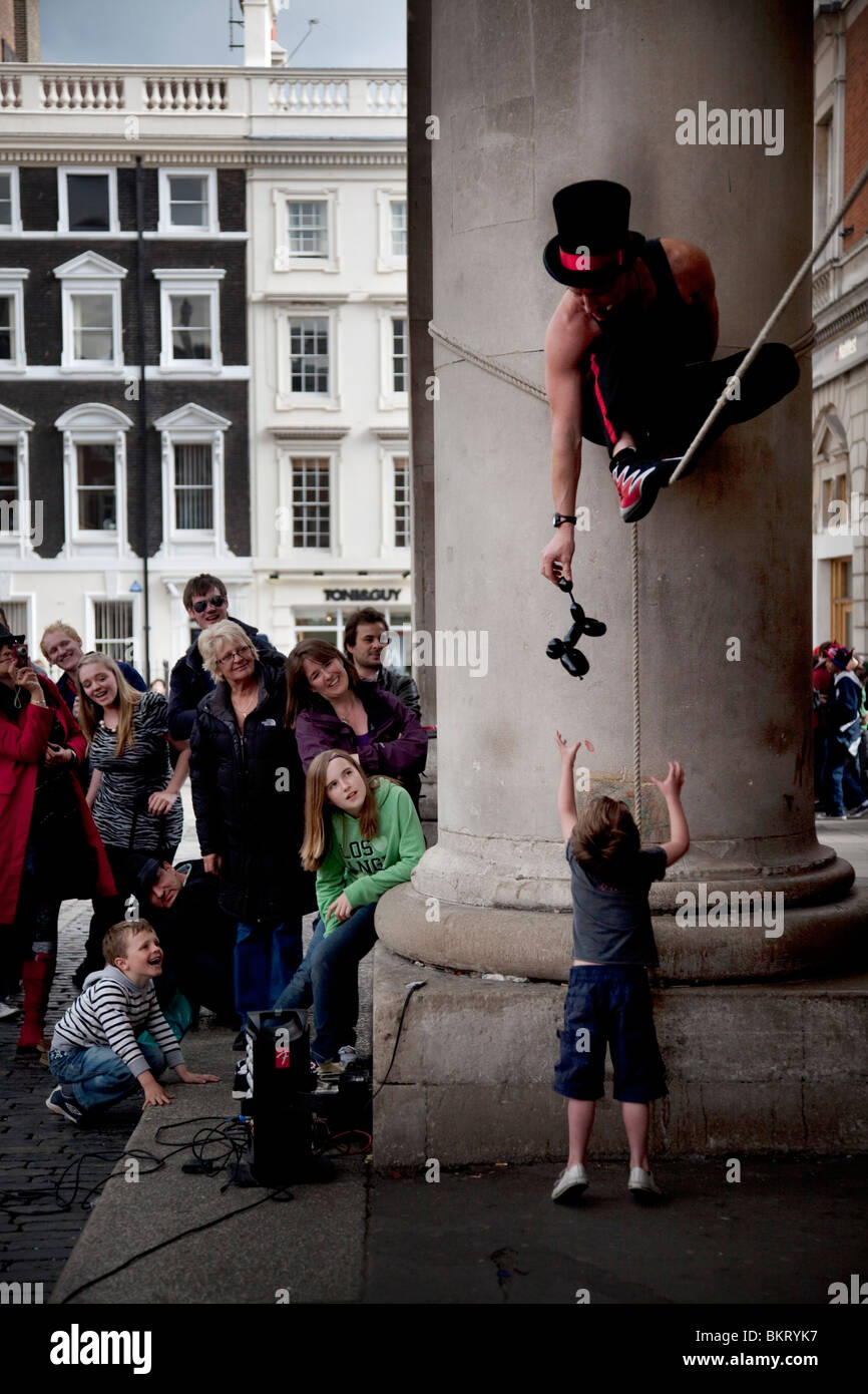Street performer thrills the crowd with his knife juggling act whilst ...