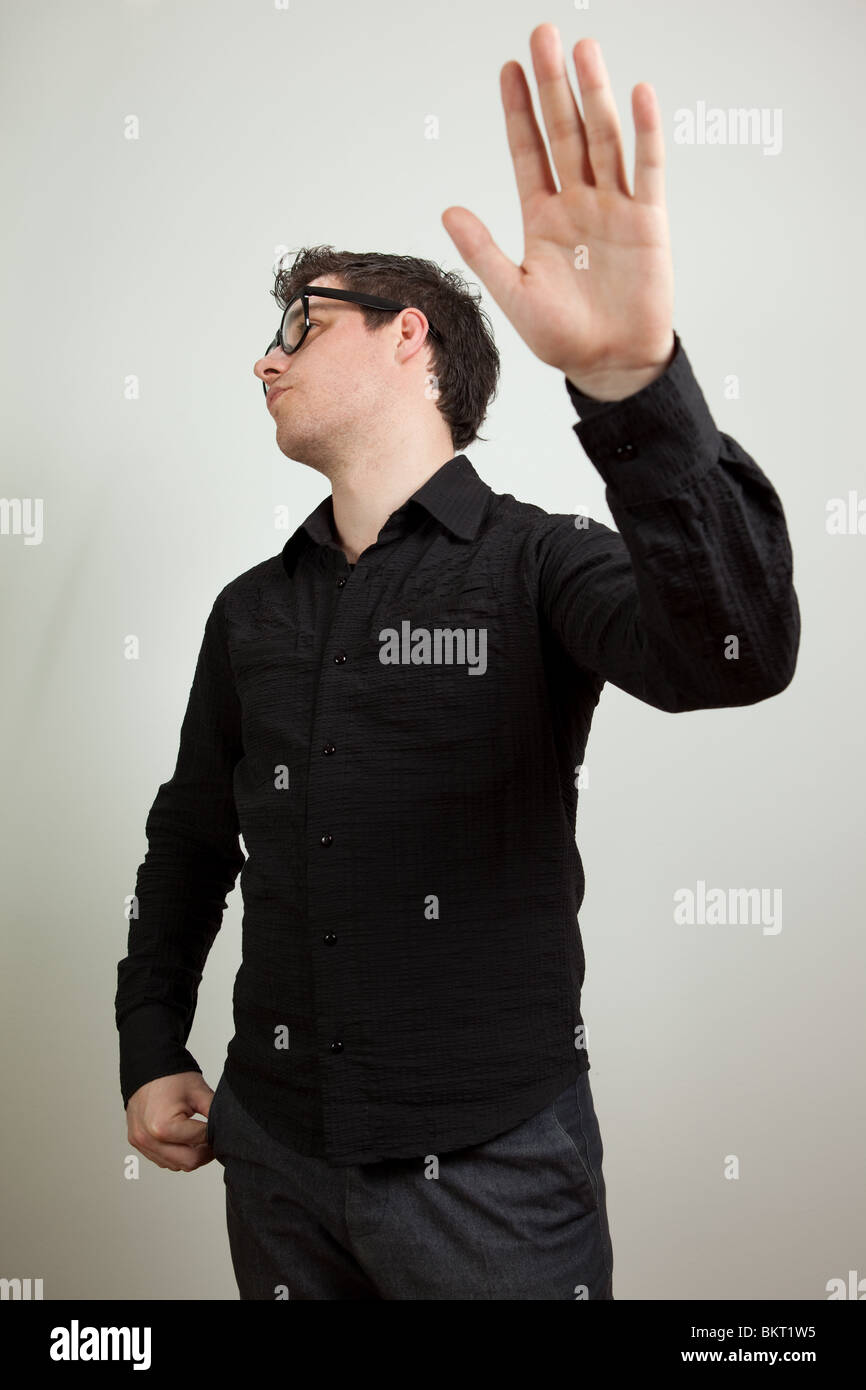 Young man standing and waving Stock Photo - Alamy