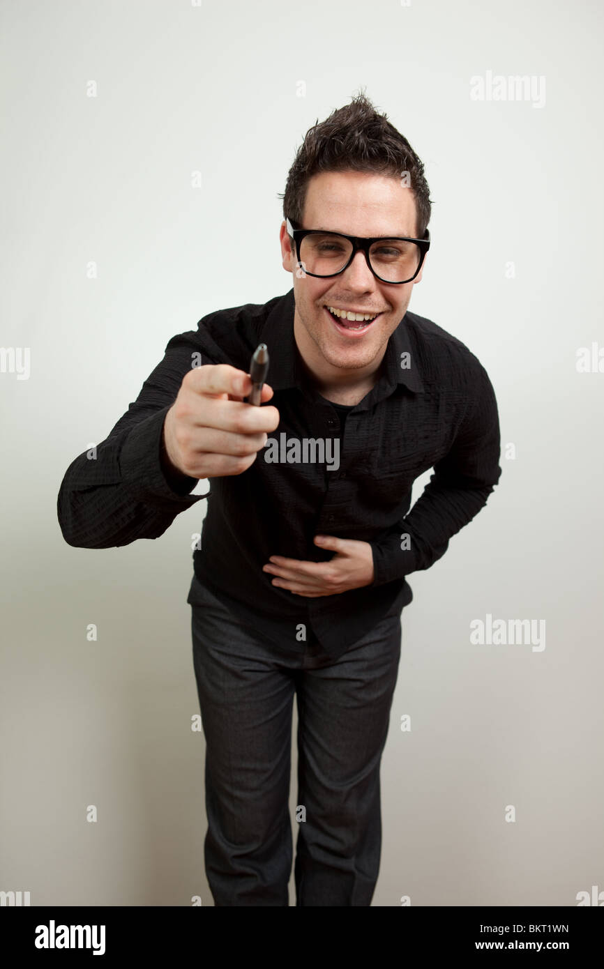 Young man standing and laughing Stock Photo - Alamy