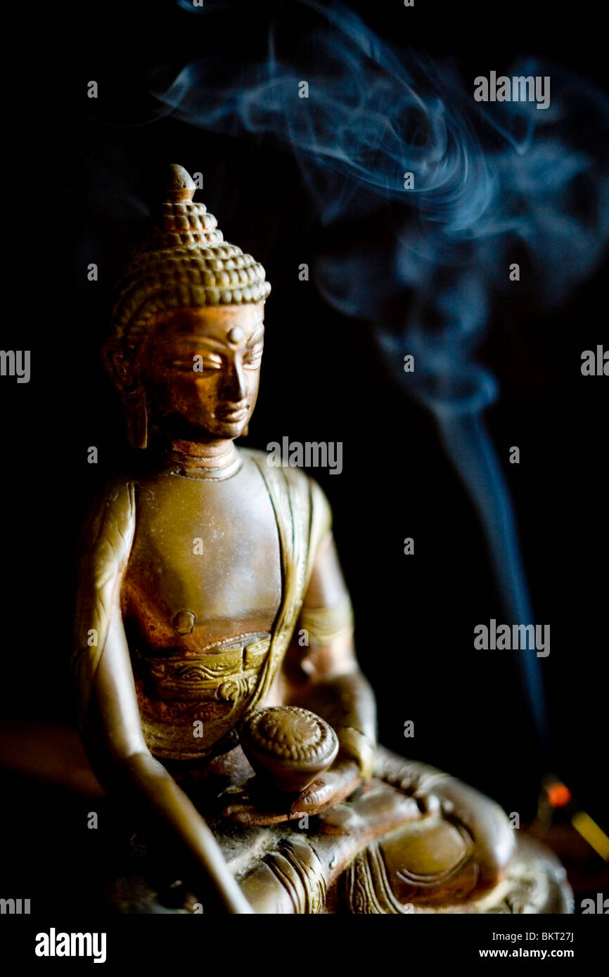 Buddha little statue with incense sticks Stock Photo - Alamy