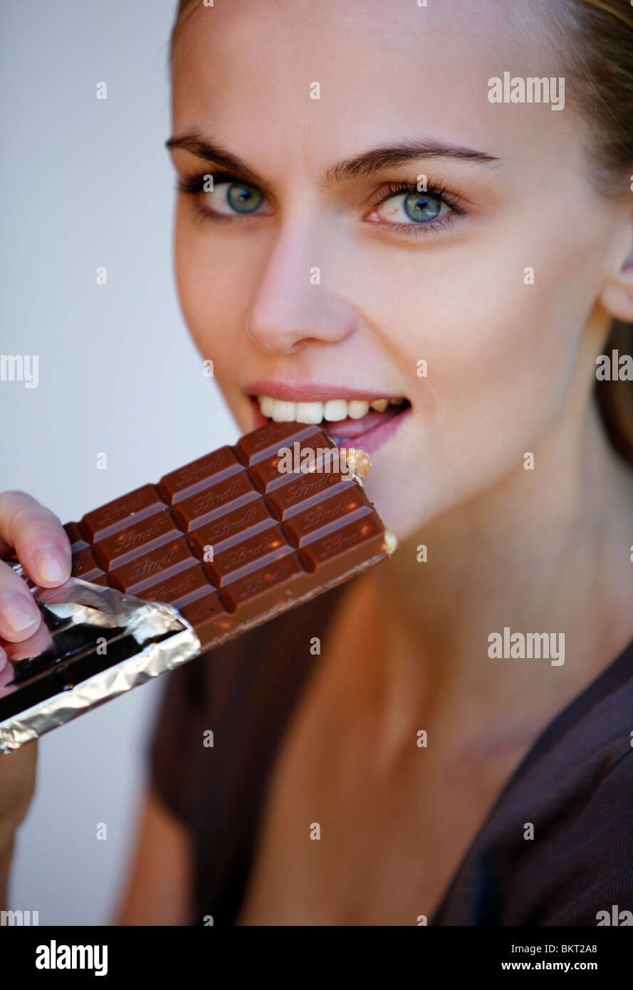 young woman eating chocolate Stock Photo - Alamy