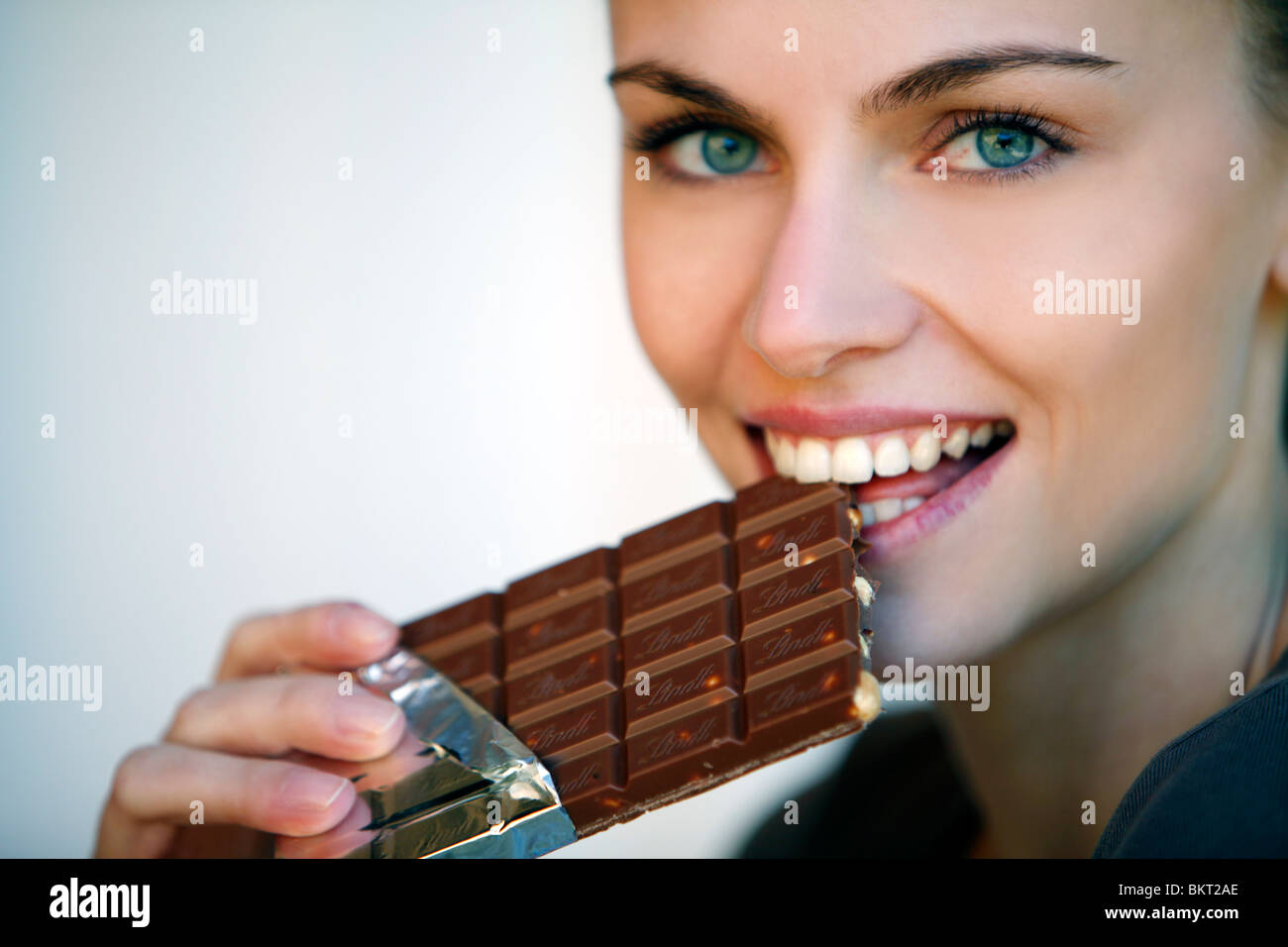 young woman eating chocolate Stock Photo - Alamy